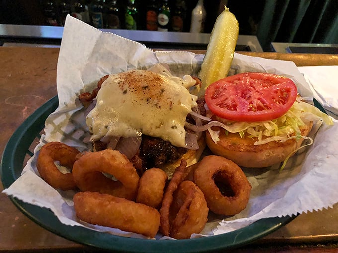 This burger with its melty cheese blanket and crispy onion rings isn't just food – it's therapy on a plate. The pickle stands guard like a tangy sentinel.