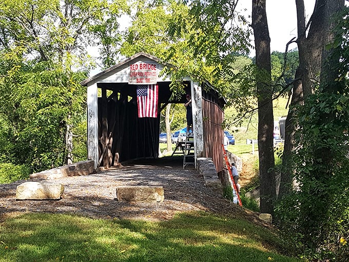Summer's embrace surrounds the entrance, with an American flag adding a splash of patriotism to this historic passageway.