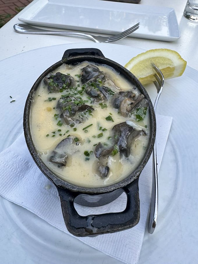 Escargot swimming in a creamy sauce with fresh herbs and a lemon wedge—the perfect introduction for the "I don't eat snails" crowd.
