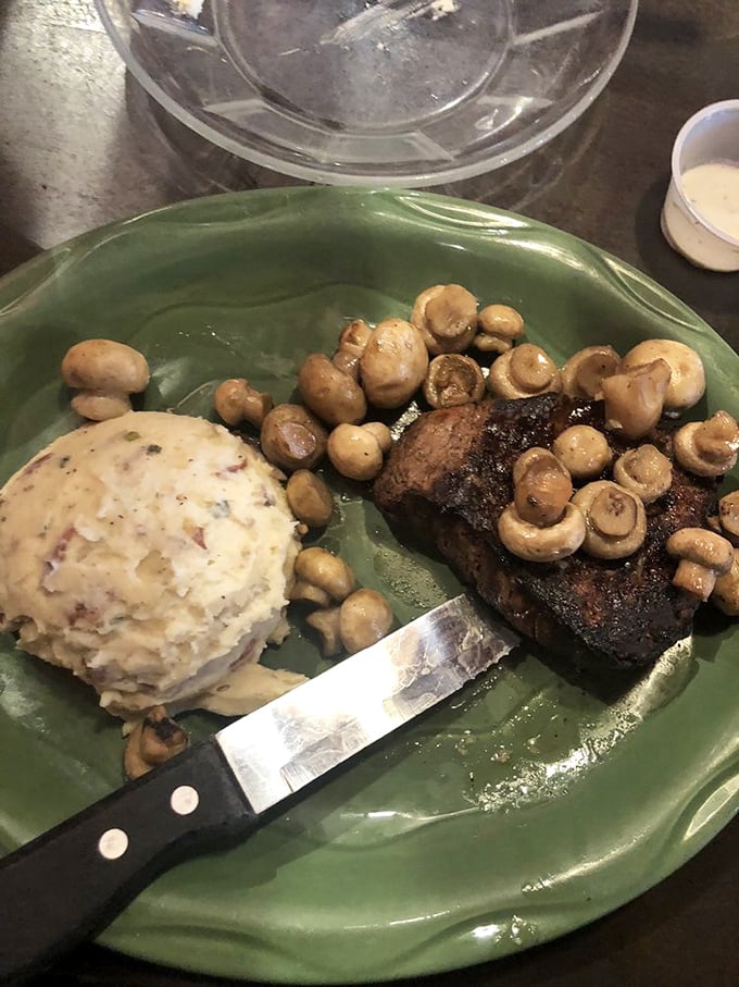 This filet mignon surrounded by mushrooms represents everything right about American steakhouse dining – pure, unapologetic indulgence at its finest.