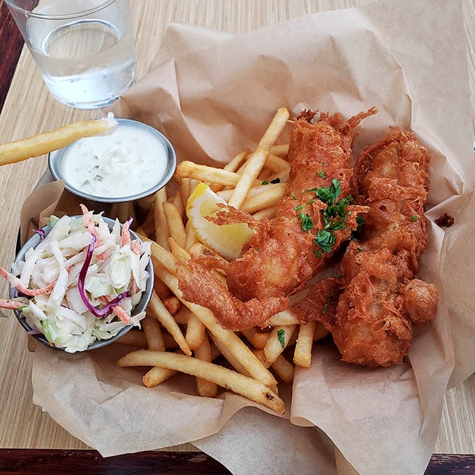 Fish and chips done right—crispy, golden batter protecting flaky white fish, with fries and slaw that aren't afterthoughts but essential supporting characters.