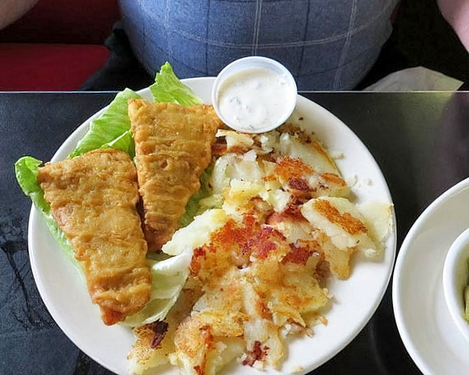 Fish so perfectly golden it belongs in Fort Knox, served with home fries that have achieved that mythical balance of crispy exterior and fluffy interior.