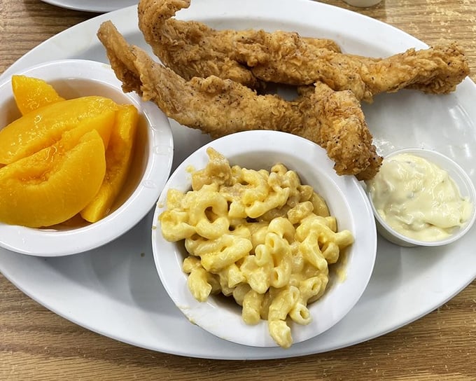 Fried chicken tenders with mac and cheese and fresh peaches – proof that sometimes the simplest combination creates the most profound happiness.