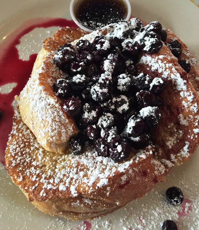 French toast elevated to art form—those blueberries aren't just toppings, they're the crown jewels in this breakfast kingdom of powdered sugar snow.