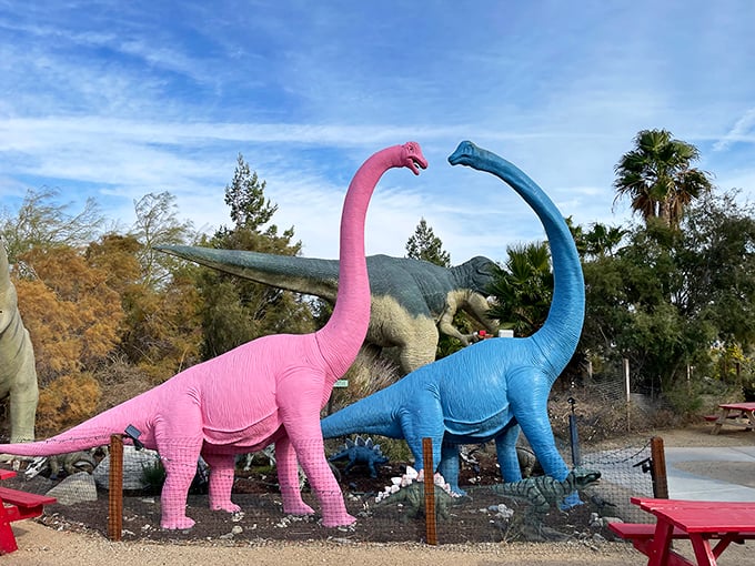 The colorful long-necked duo looks like they're sharing prehistoric gossip while visitors snap photos below. "Did you hear what the stegosaurus said?"