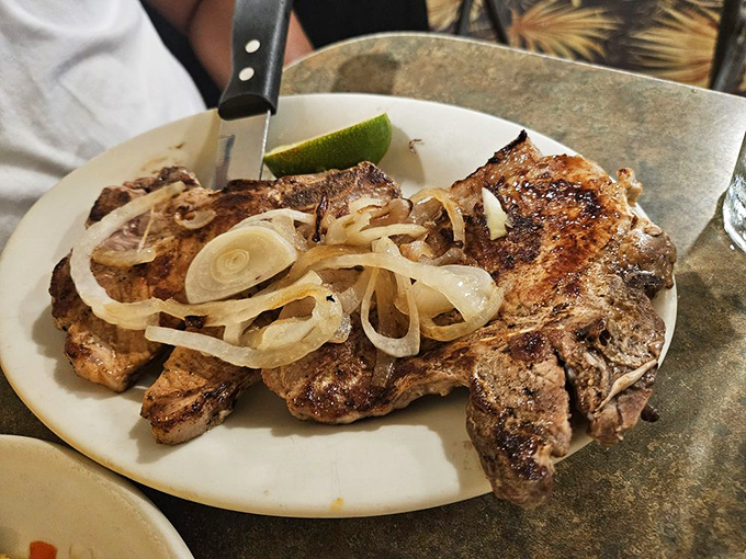 Grilled pork chops topped with caramelized onions prove that sometimes the simplest preparations create the most memorable meals.
