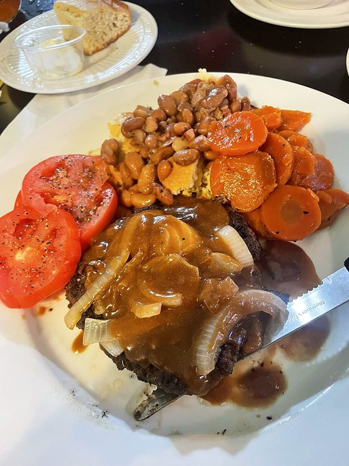 This hamburger steak isn't just covered in gravy – it's swimming in a savory pool with beans and vegetables cheering from the sidelines.