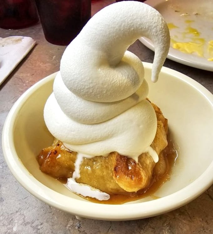 That's not just whipped cream—that's a cloud-like masterpiece defying gravity atop a warm apple dessert that would make even the most dedicated dieter surrender.