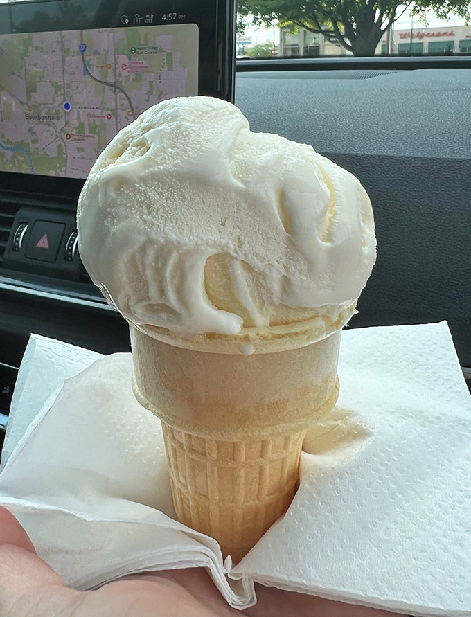 Ice cream that stands tall and proud in its cone—a vanilla mountain that demands to be conquered before it surrenders to the summer heat.