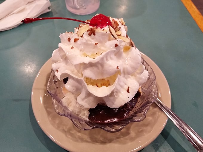 Ice cream sundae architecture at its finest—hot fudge pooling at the bottom, whipped cream defying gravity, and that cherry on top that makes everything official.