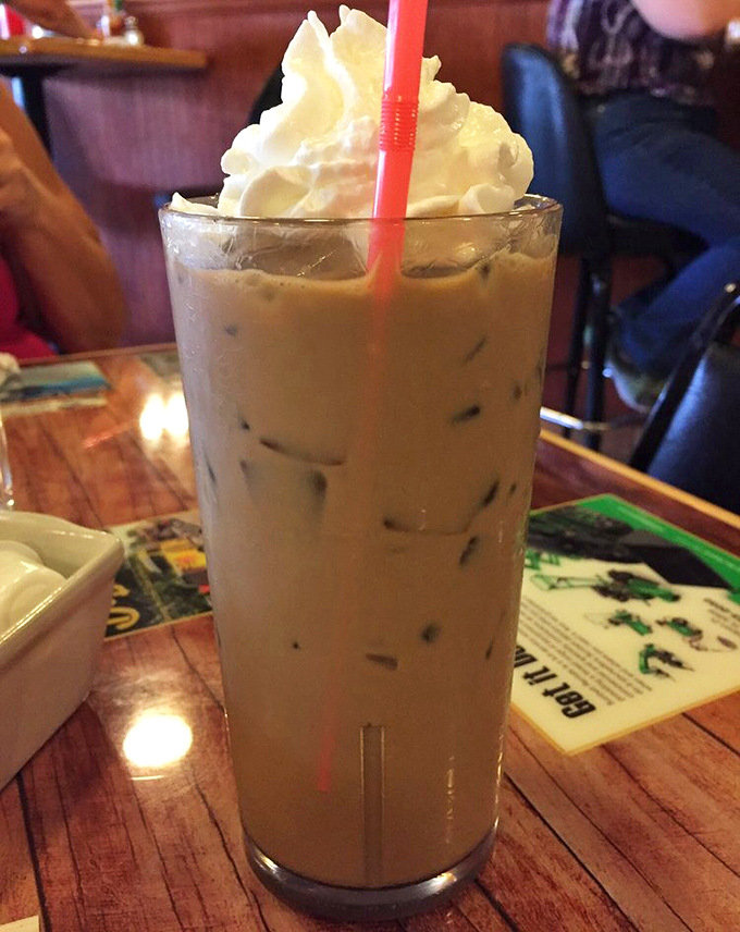 Iced coffee topped with a cloud of whipped cream – because sometimes adulting requires both caffeine and dessert simultaneously.