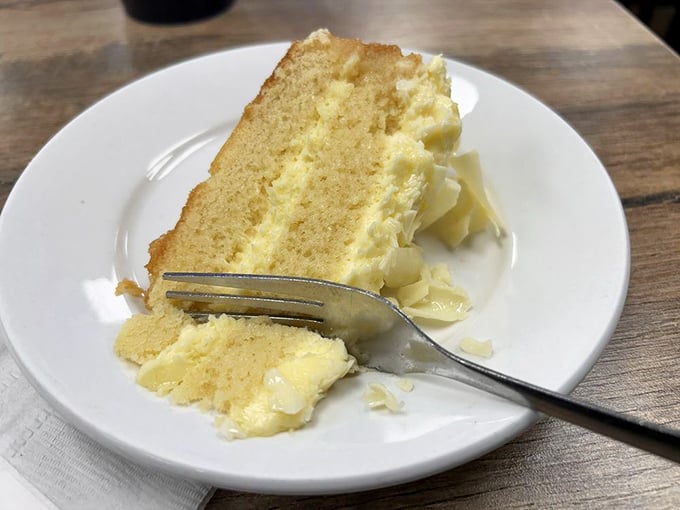 A slice of cake so light and fluffy it practically floats off the plate. Dessert isn't optional here—it's the final movement in a soul food symphony.