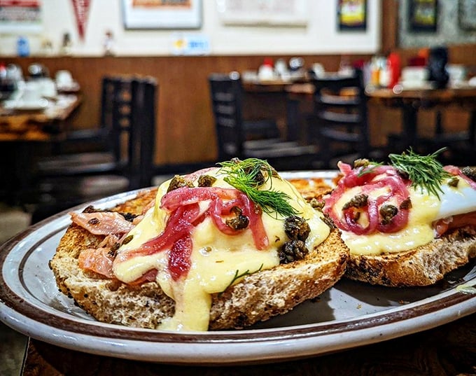 The Lox Benedict elevates breakfast with silky smoked salmon, vibrant pickled onions, and capers atop crusty bread – a symphony of flavors that dance across your palate.