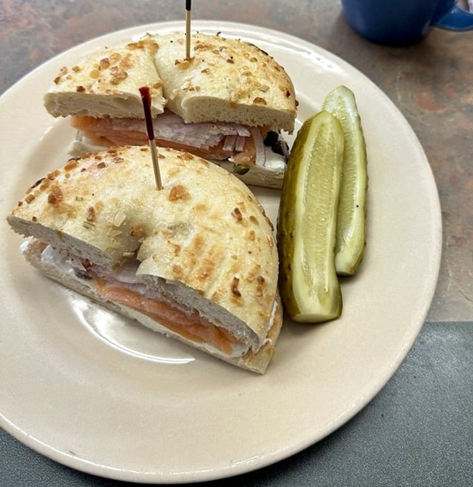 The lox bagel sandwich—proof that sometimes the simplest combinations are culinary genius. Those pickles standing at attention know they're in the presence of greatness.