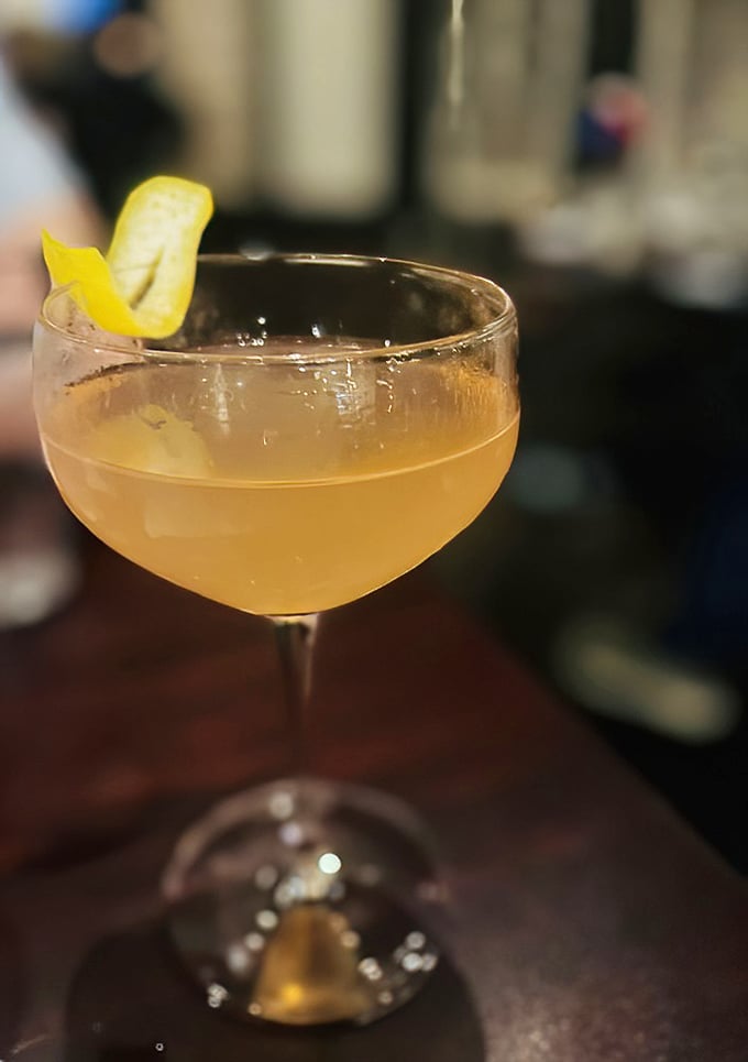 A perfectly crafted cocktail that captures liquid sunshine in a glass, complete with that essential citrus twist garnish.