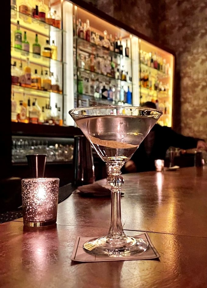 A proper martini at Butcher and Singer isn't just a drink—it's liquid architecture, glistening with possibility against the amber glow of the bar.