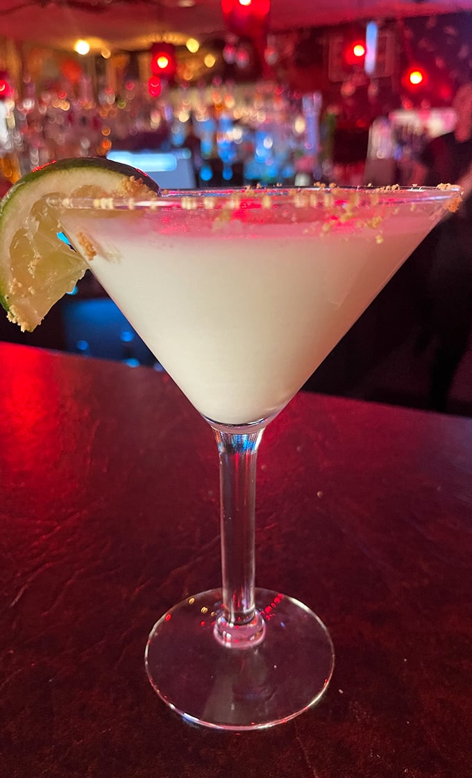A proper martini with a lime garnish, served in a glass so perfectly chilled it practically whispers "sophistication" with every sip.