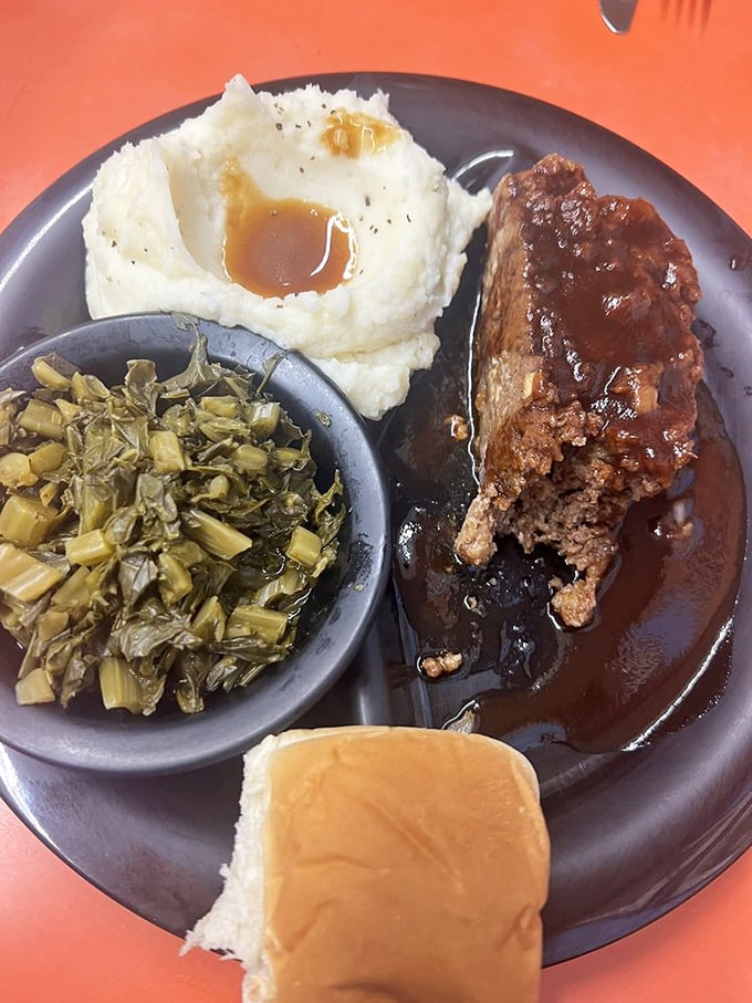 Meatloaf swimming in gravy alongside collard greens and mashed potatoes – the holy trinity of Southern comfort that hugs you from the inside.