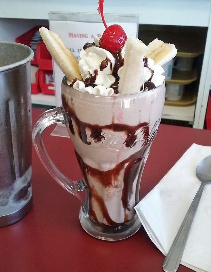 This isn't just a milkshake—it's dessert architecture. Bananas, whipped cream, and chocolate drizzle create a tower of happiness in a glass mug.