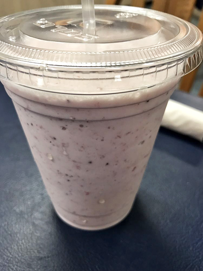 A berry milkshake thick enough to require serious straw commitment – the kind that makes you wonder why anyone bothers with those fancy $15 city versions.