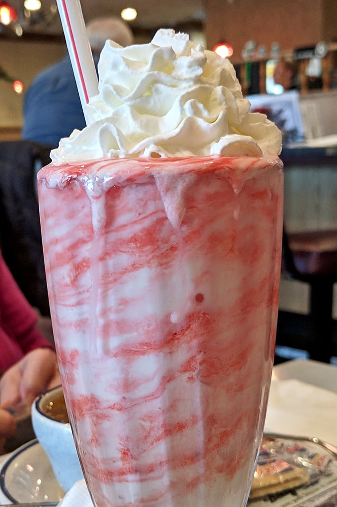This strawberry milkshake isn't just a drink, it's a towering achievement in dairy architecture that demands both a spoon and straw.