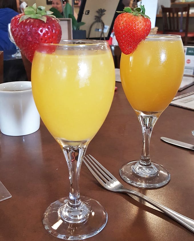Mimosas garnished with fresh strawberries—because nothing says "today is special" like champagne before noon in elegant glassware.