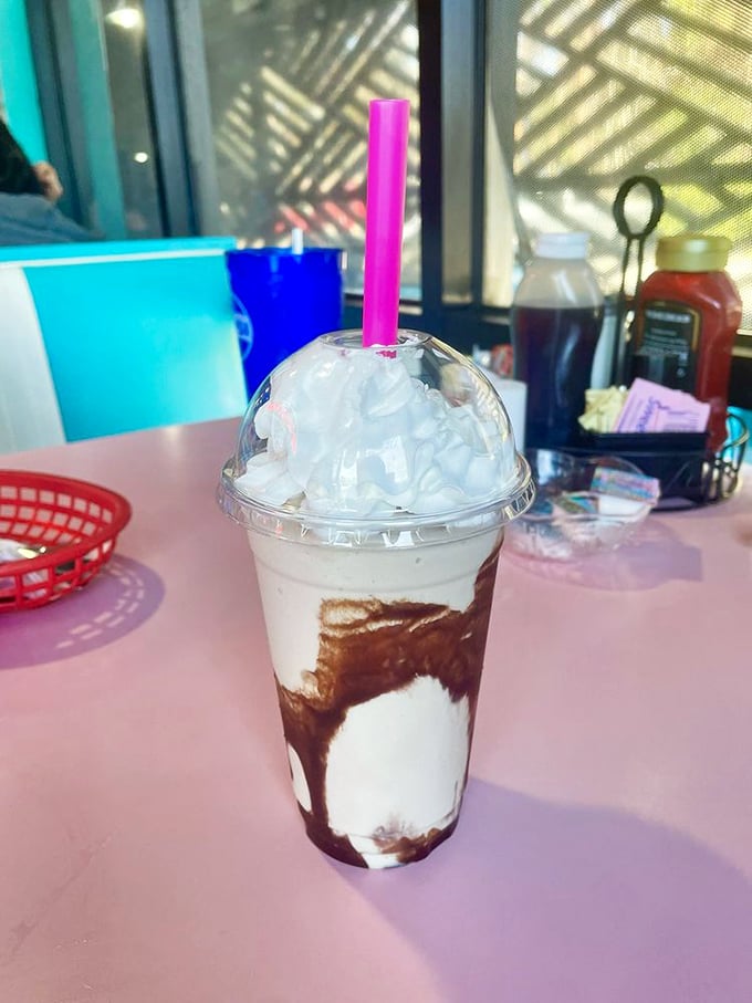 This mocha milkshake isn't just a drink—it's dessert in disguise, wearing a whipped cream hat and bringing joy through a pink straw.