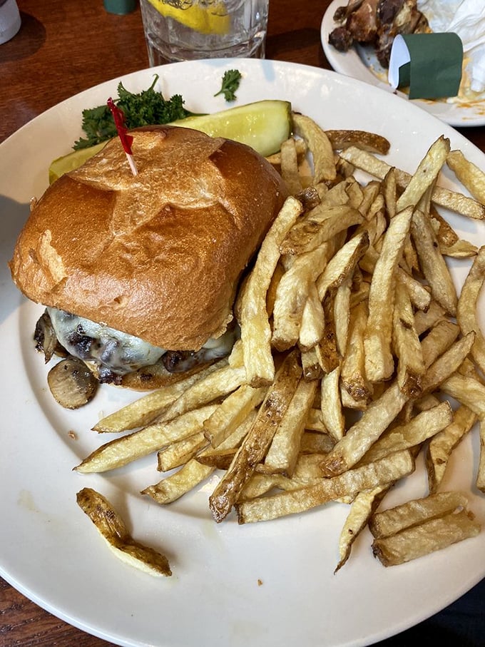 This burger isn't just food—it's a skyscraper of satisfaction with fries that look like they're auditioning for a potato commercial.