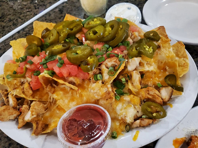 These aren't just nachos—they're a fiesta of textures and flavors where jalapeños, tomatoes, and melted cheese throw the kind of party your taste buds talk about for days.