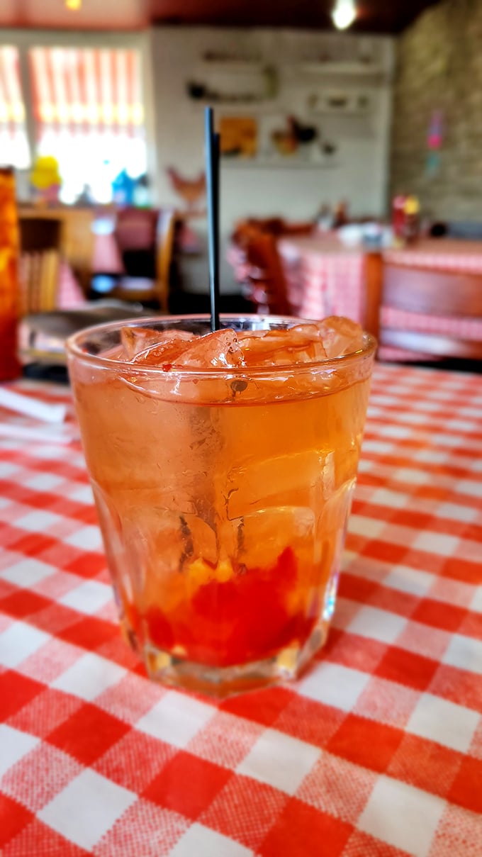That's not just any cocktail – it's an Old Fashioned sitting pretty on a checkered tablecloth, waiting to wash down all that glorious fried goodness.