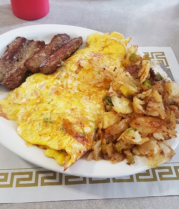 An omelet that's had a proper education – folded with dignity, stuffed generously, and paired with home fries that deserve their own fan club.