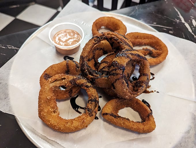 Onion rings drizzled with what appears to be balsamic reduction – because even side dishes deserve their moment in the spotlight.