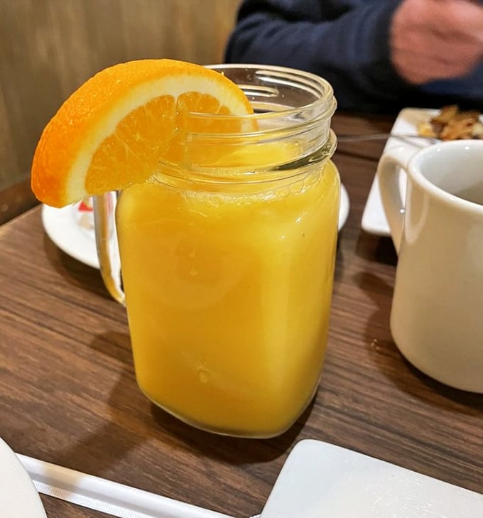 Fresh-squeezed orange juice served in a mason jar with an orange slice garnish – liquid sunshine to brighten your morning.