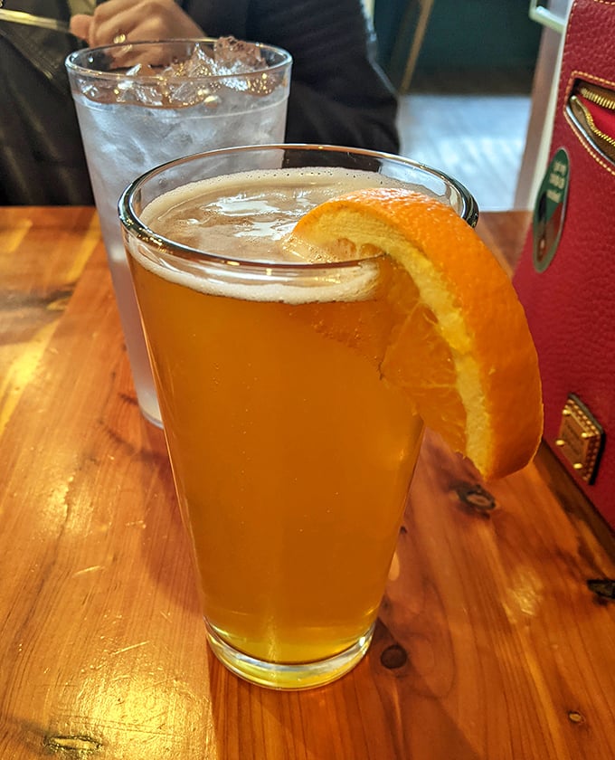 Even the beverages get special treatment here—a craft beer garnished with orange, because when you're eating like royalty, your drink deserves a crown too.