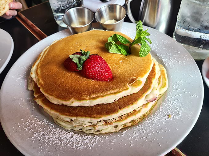 These pancakes aren't just breakfast, they're an event—a towering golden monument to morning happiness, crowned with a strawberry and mint tiara.