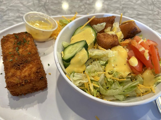 A study in contrasts: crispy breaded fish alongside a fresh garden salad. Like wearing a tuxedo with sneakers—unexpected but somehow just right.