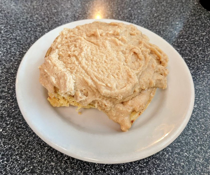 This isn't just dessert, it's therapy—a cinnamon roll wearing a thick coat of peanut butter frosting that makes all your problems temporarily disappear.