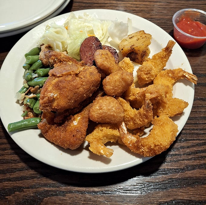 A plate that tells the story of American buffet excellence: crispy fried chicken, savory sausage, and fresh vegetables playing supporting roles to perfection.