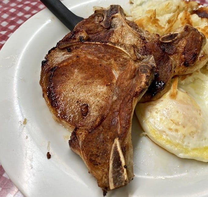 This pork chop isn't just cooked – it's respected. Sitting alongside those sunny eggs and hash browns, it's the breakfast trifecta of champions.