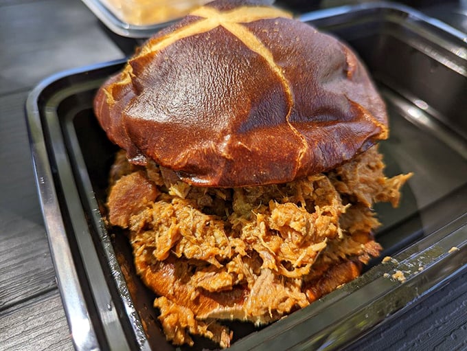 This pulled pork sandwich isn't just lunch – it's a commitment to excellence piled high on a bun that's brave enough to contain such magnificence.