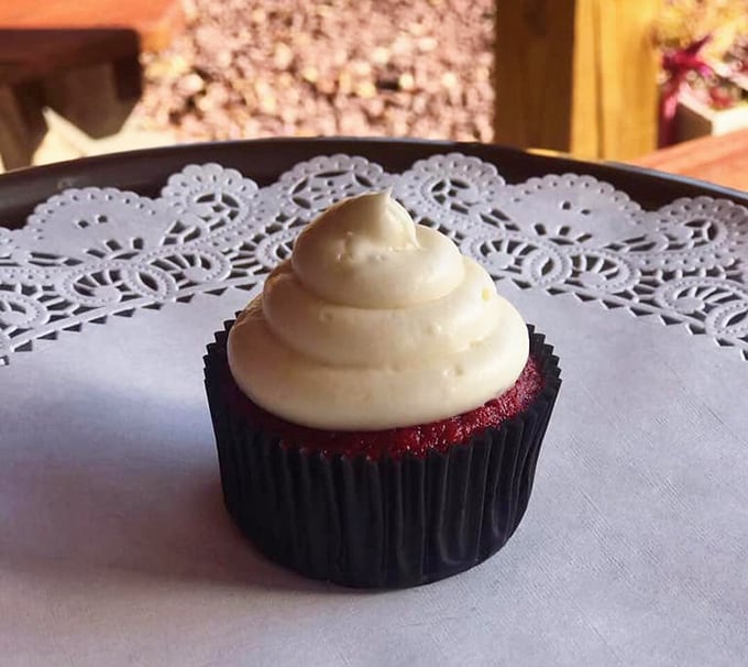 Red velvet cupcake sitting pretty on a doily – because even tough barbecue joints have a soft spot for proper dessert presentation.