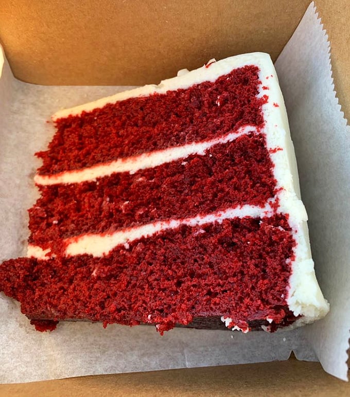 Three perfect layers of red velvet cake with cream cheese frosting so pristine it looks Photoshopped—but trust me, it's gloriously real.