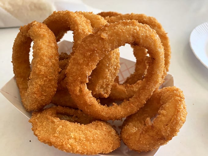 These onion rings aren't just fried—they're golden halos of crispy perfection that make you wonder why vegetables ever bothered growing any other way.