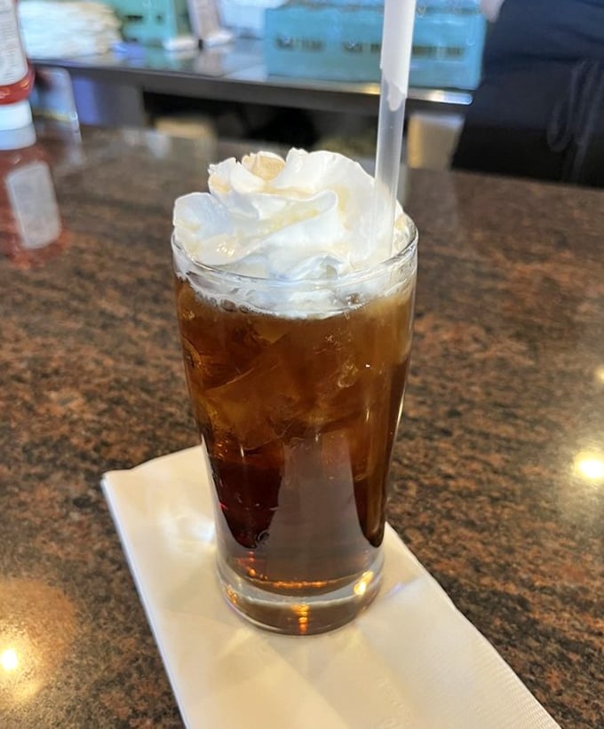 Root beer float topped with whipped cream clouds – childhood nostalgia served in a perfect glass.