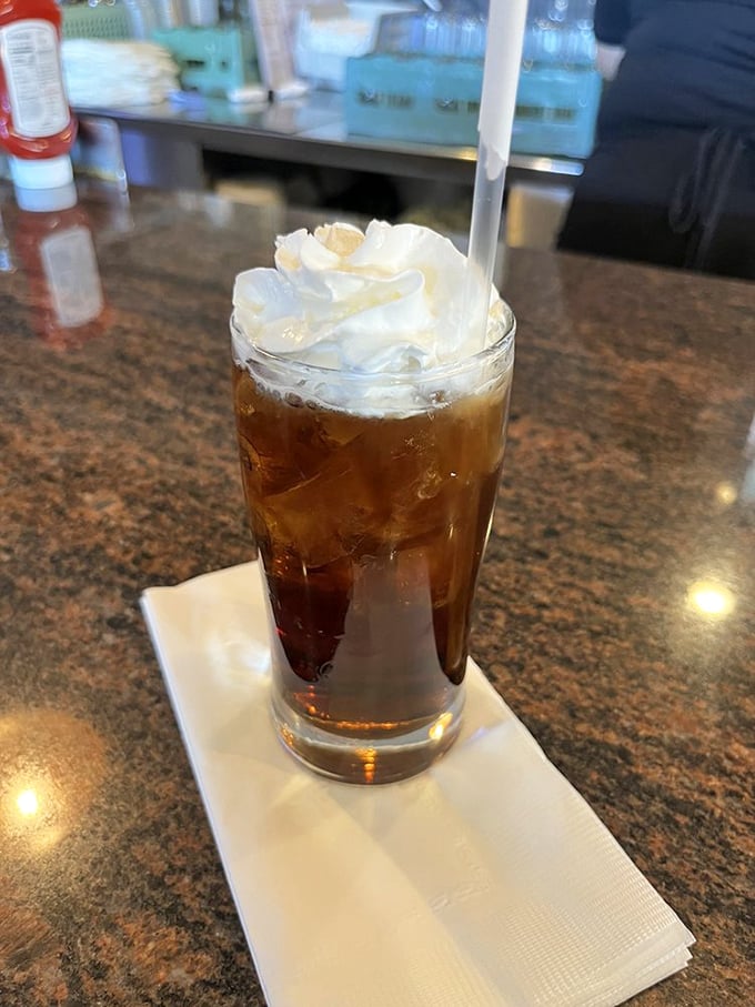 Nostalgia in a glass! This root beer float topped with a cloud of whipped cream proves some childhood pleasures only get better with age.