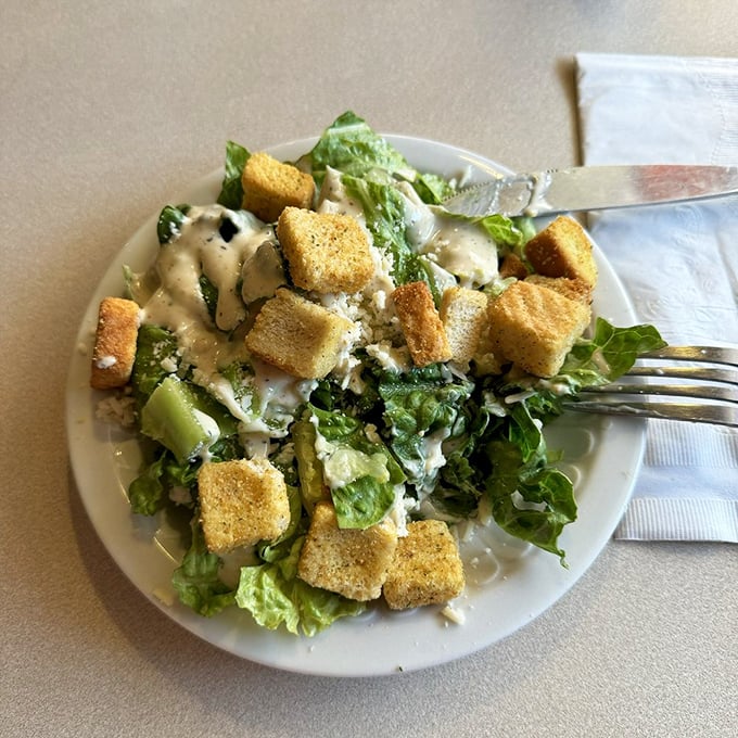 A classic Caesar salad that proves sometimes the simplest pleasures – crisp romaine, golden croutons, and tangy dressing – are the most satisfying.