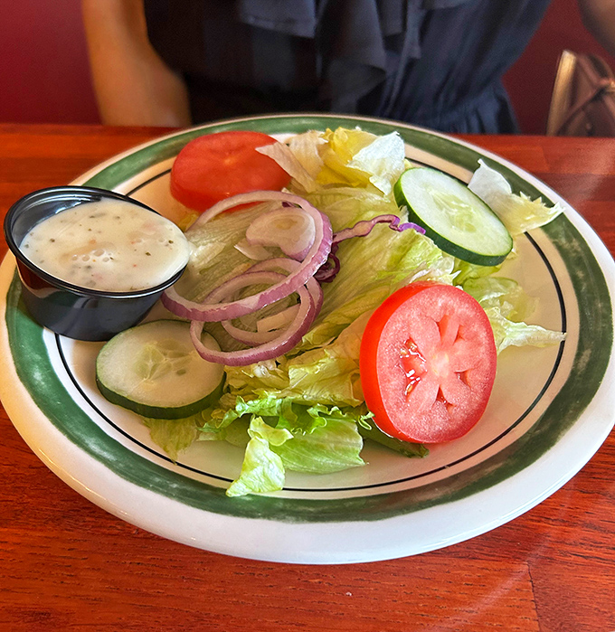 A house salad that knows its role—fresh, crisp, and ready to provide the illusion that you're making healthy choices before your steak arrives.