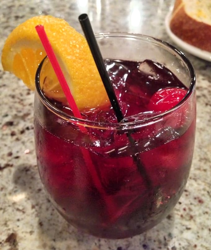 A ruby-red sangria garnished with orange—because sometimes watching boats bob in the harbor requires a drink as pretty as the view.