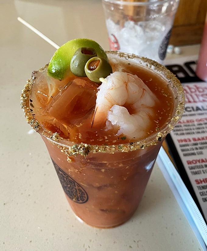 A Bloody Mary garnished with shrimp and olives – because sometimes your cocktail should double as an appetizer.
