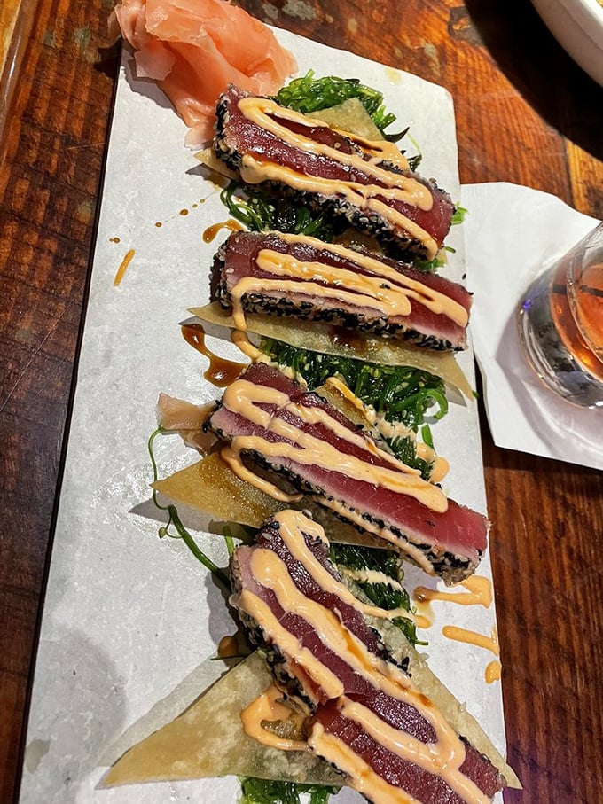 Seared tuna that's dressed to impress—ruby red centers with a sesame crust and that sauce drizzled like edible modern art.